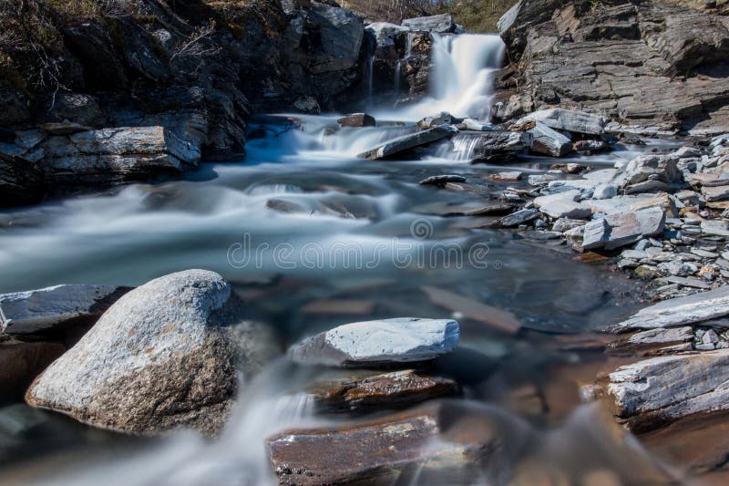 Long Exposition Shot of a River with Silk Effect on the Water, while the Rocks and Background ...