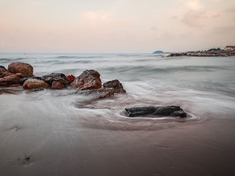 Long Exposure Effect of Ocean Waves Hitting the Sandy Beach with Stones ...