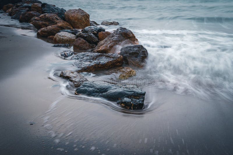 Long Exposure Effect of Ocean Waves Hitting the Sandy Beach with Stones ...