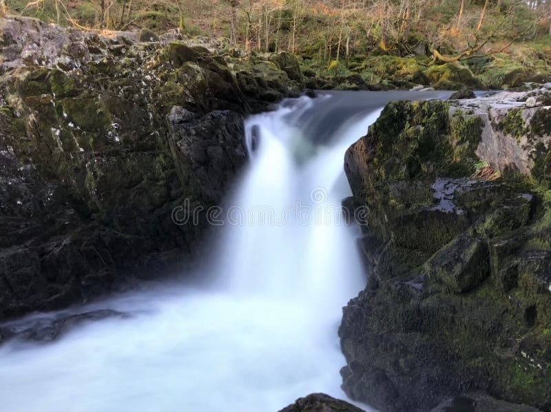 Long Exposure of a Flowing Waterfall between Rocky Mossy Cliff in the ...
