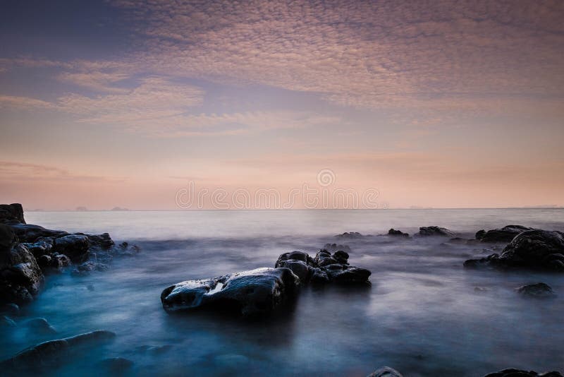 Long Exposure Image of Dramatic Sky and Wave with Rock Sea in Sunset ...