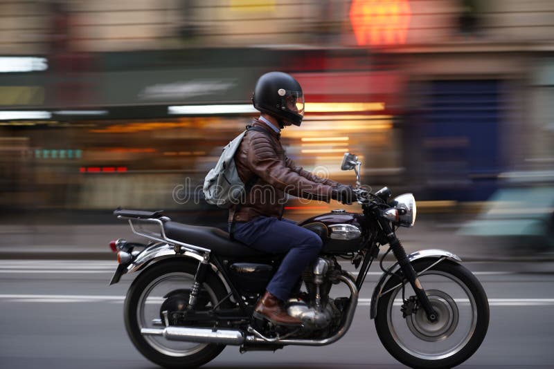Long Exposure of a Man Riding a Motorcycle with Buildings in the ...