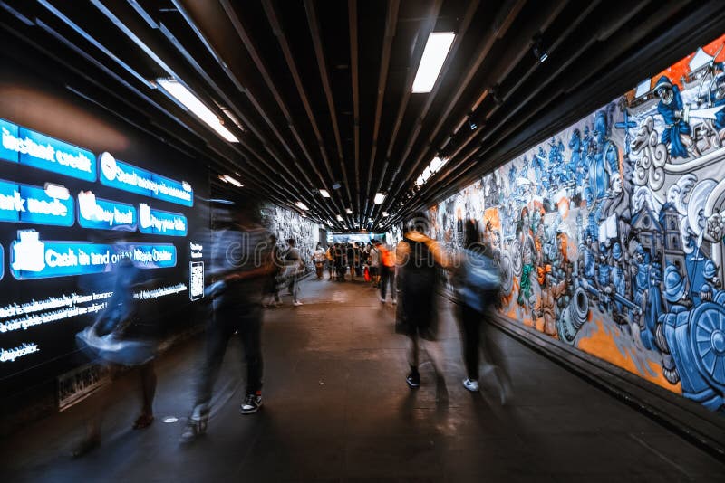 Long Exposure of People Walking in the Underpass with Graffiti Art on ...
