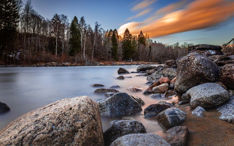 Long Exposure Shot of a Beautiful Sunset Over the Rocky Lagan River ...