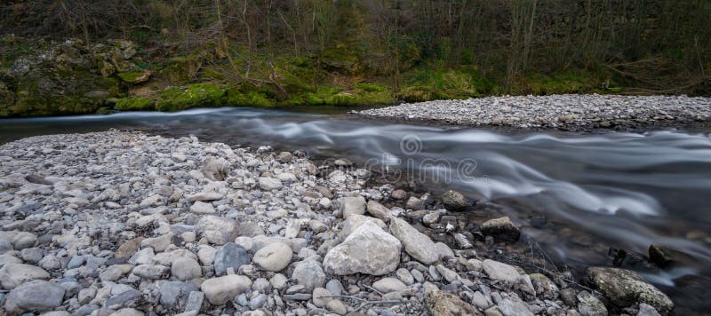 Long Exposure Shot of Flowing Stream with Rocks on the Shore Stock ... Long Exposure Shot of Flowing Stream with Rocks on the Shore Stock ...