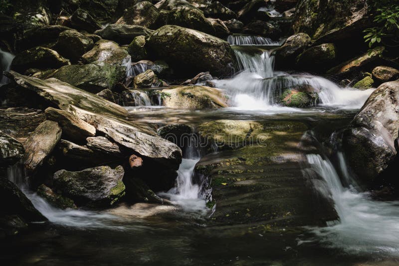 Long Exposure Shot of a Water Stream Passing through the Rocks in the ... Long Exposure Shot of a Water Stream Passing through the Rocks in the ...