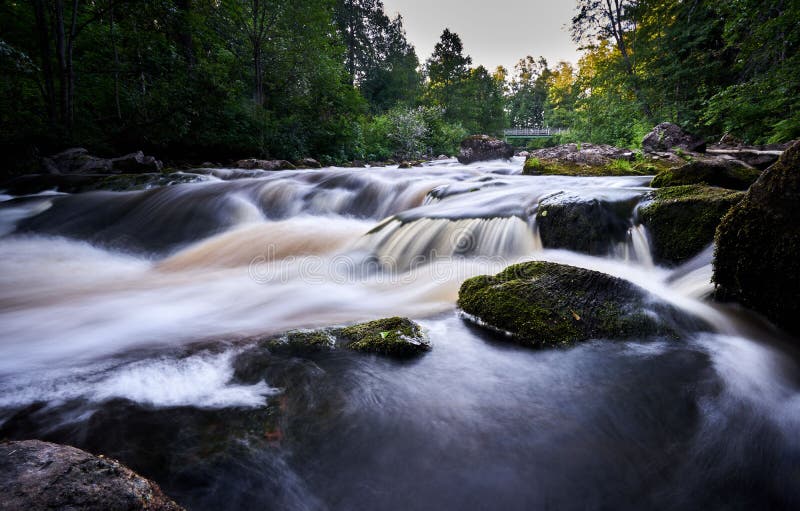 Long Exposure Shot of a Waterfall Flowing Over Rocks in a Forest with ...