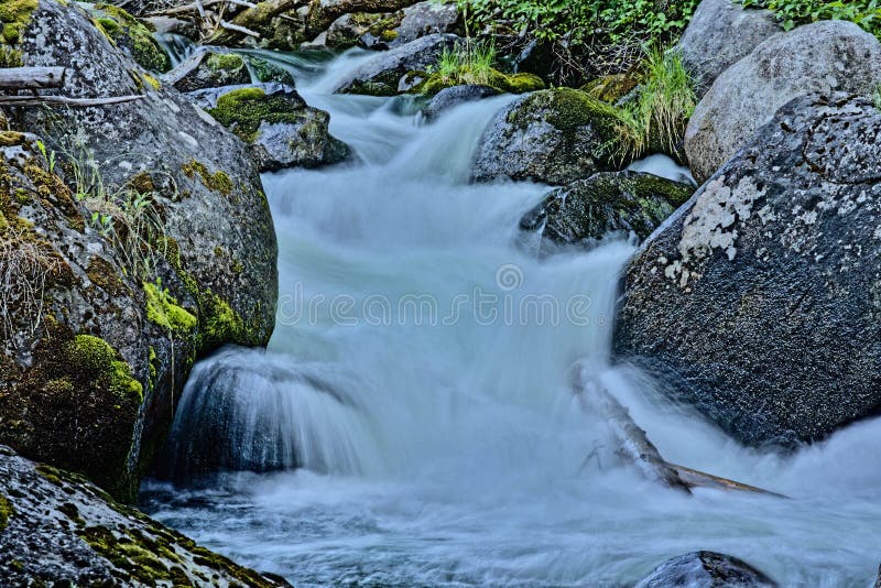 Long Exposure Shot of a Waterfall Streaming between Rocks with Greenery ...