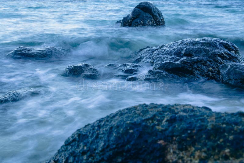 Long Exposure Smooth Ocean Wave Moving into Rock. Stock Image - Image ...