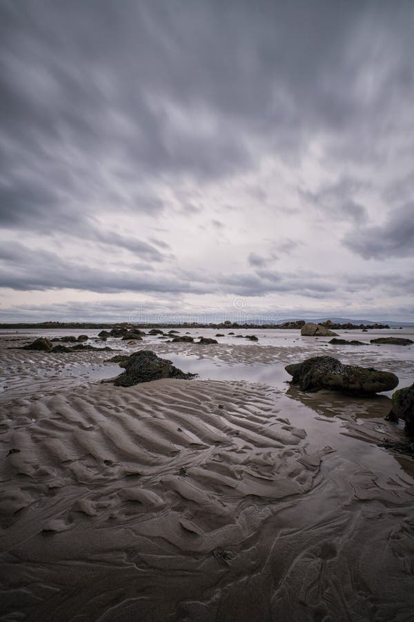 Long Exposure View of Sandy Beach with Rocks by Sea Water Under ...