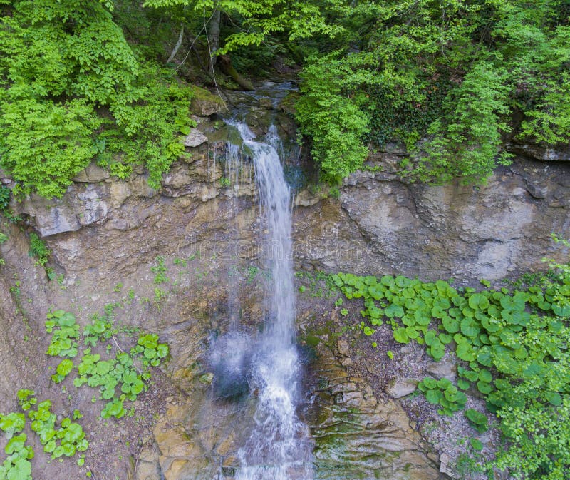 Long the Flow of the Waterfall Cascading from the Cliff. Aerial Stock ...
