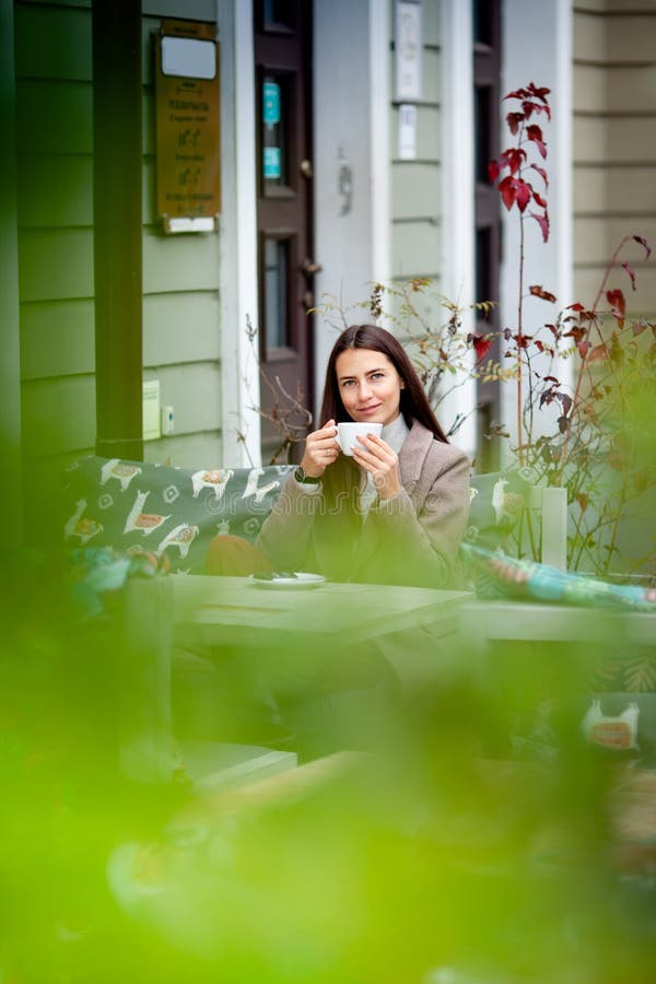 Beautiful Long-haired Brunette Drinking Coffee at the Table of a Street ...
