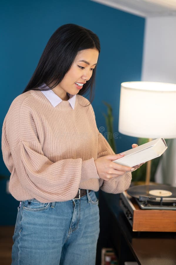 Long-haired Girl Holding a Book in Hands and Smiling Stock Photo ...