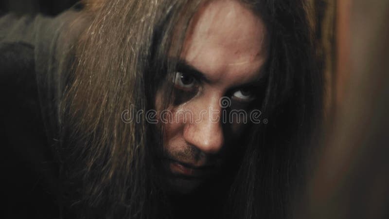 A Long-haired Guy with a Deep Evil Look Looks in the Mirror. Close Up ...