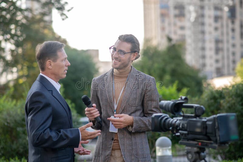 Male Journalist Taking Taking Inteview with Mature Man, Recording it ...