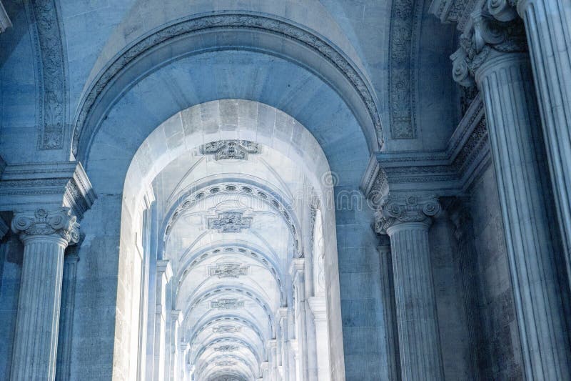 A Long Hallway Features Many Arches and Columns in a Major Building ...