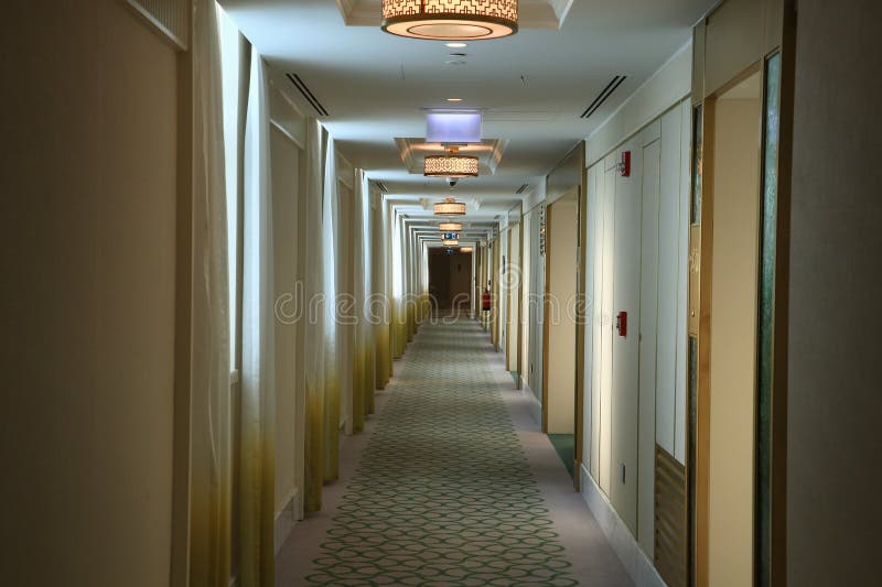 Long Hotel Corridor with Patterned Carpet, Doors on Either Side, and ...