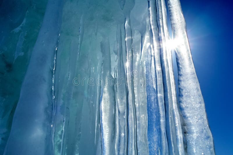 Long Icicles Made of Ice Against Blue Sky and Sun Stock Photo - Image ...