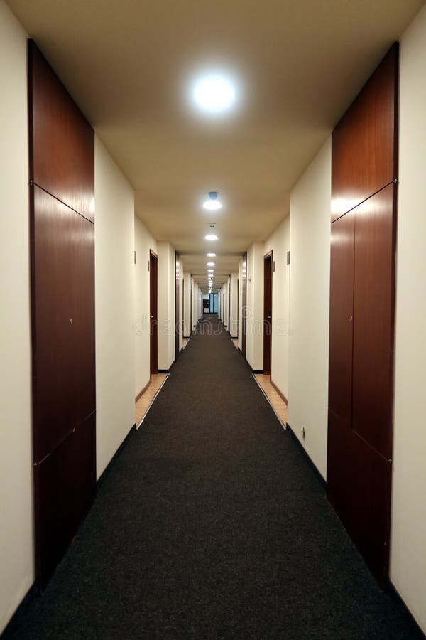 A Long Illuminated Corridor with Doors on Both Sides Stock Photo ...