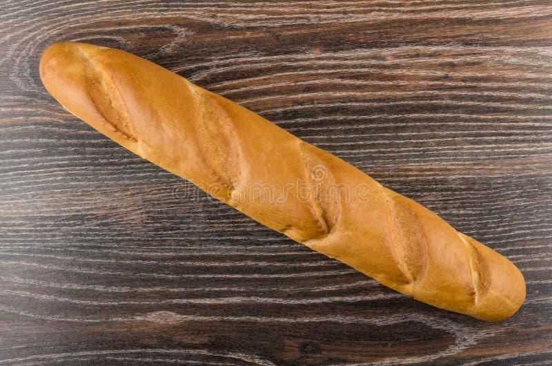Long Loaf of Bread on Dark Wooden Table Stock Image - Image of baked ...