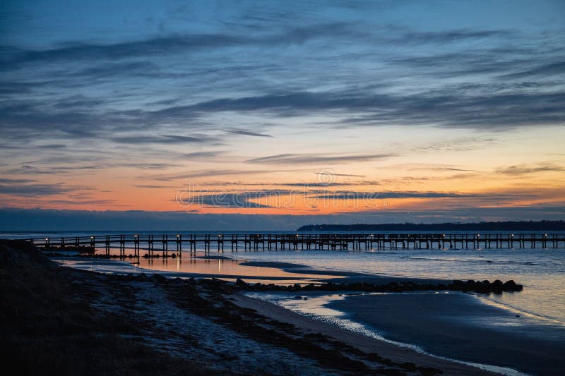 Long Pier at Sea Against a Sunset Sky Stock Image - Image of horizon ...