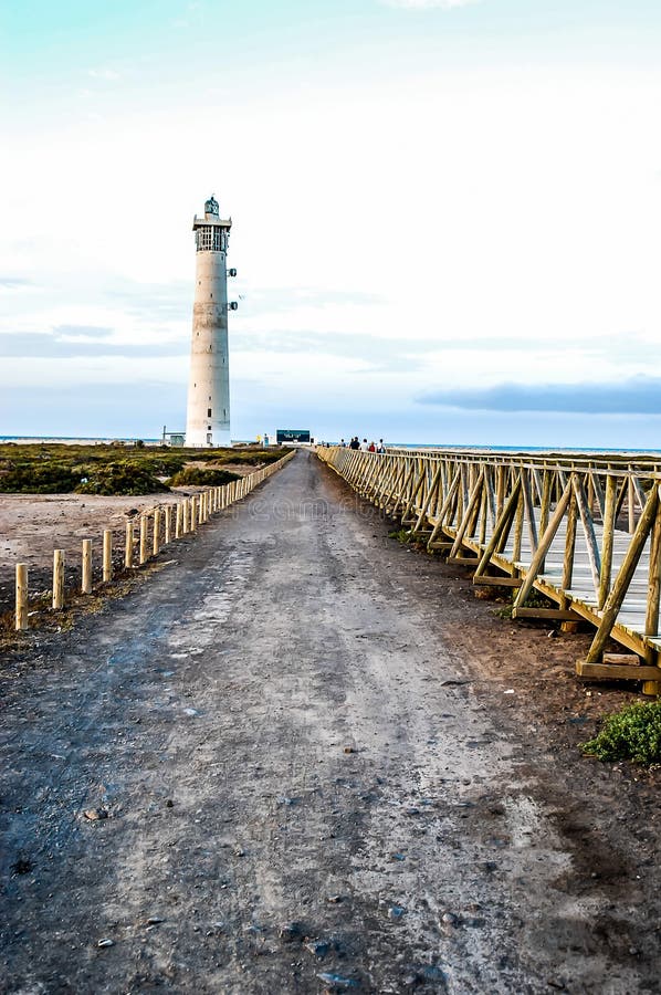 A Long Road with a White Lighthouse in the Distance Stock Photo - Image ...