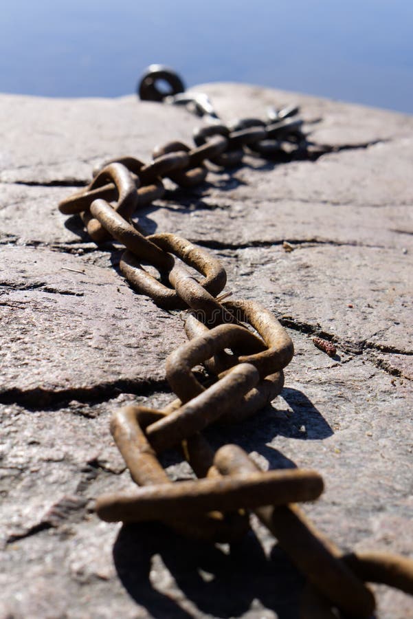 A Long Rusty Chain on Some Rocks Stock Photo - Image of rust, long ...