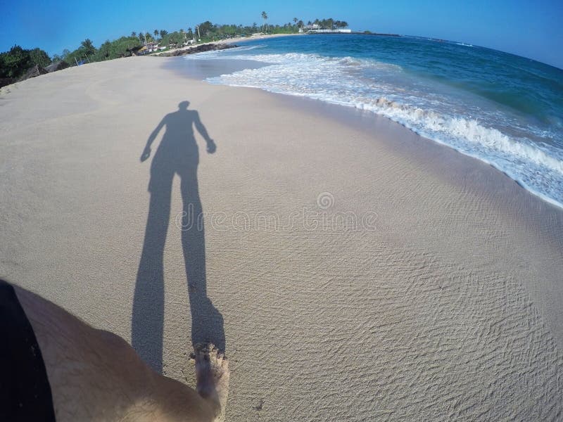 Long Shadow of a Man on the Beach by Blue Ocean in Summer Stock Photo ...