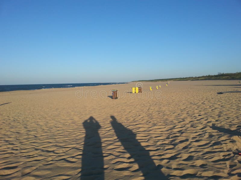 Long shadows on the beach stock image. Image of blue - 113498659