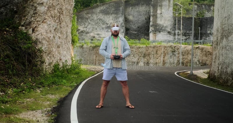 FPV Pilot Stands in a Canyon and Controls a Drone Using Goggles. Stock ...