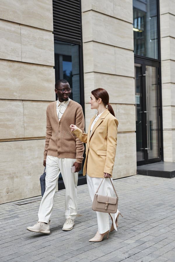 Long Shot of Two Young Managers in Quiet Luxury Attire Walking Down ...