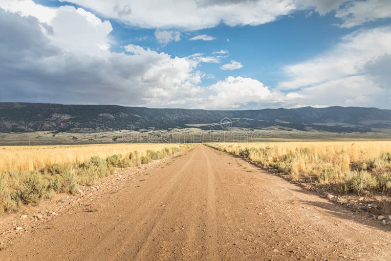 Long Straight Dirt Road in Utah with Dramatic Clouds Stock Photo ...