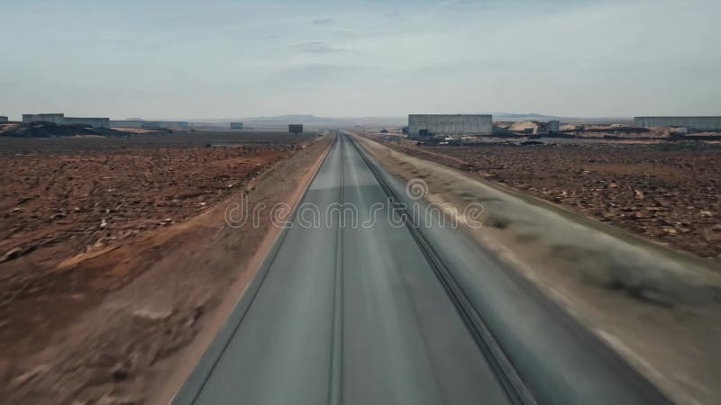 A Long, Straight Road Cuts through a Barren, Desert Landscape Under a ...