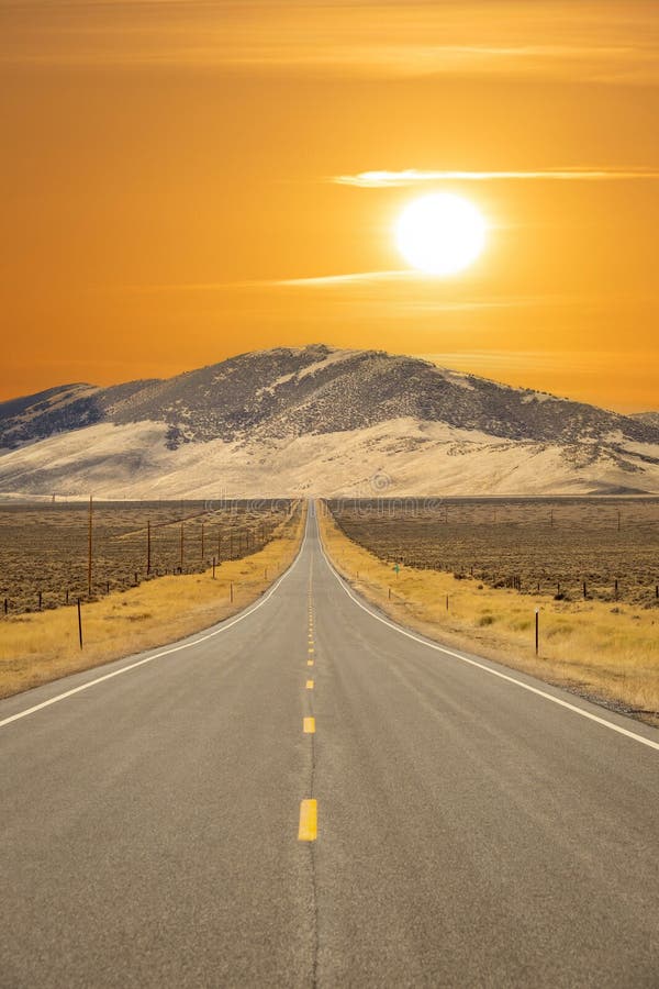 A Long, Straight Road Heading into the Sunset and Distant Mountains ...