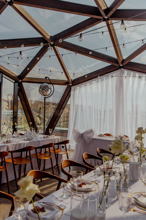 A Long Table with Plates and Glasses in a Room with a Window Stock ...