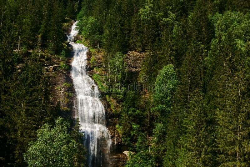 Long Waterfall Over Cliffs in a Mountain with a Forest Stock Photo ...