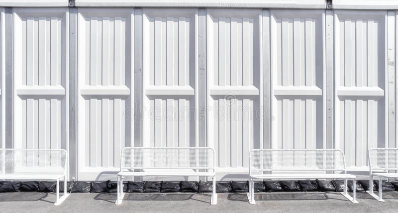Long White Metal Strip Wall with Park Benches Stock Photo - Image of ...