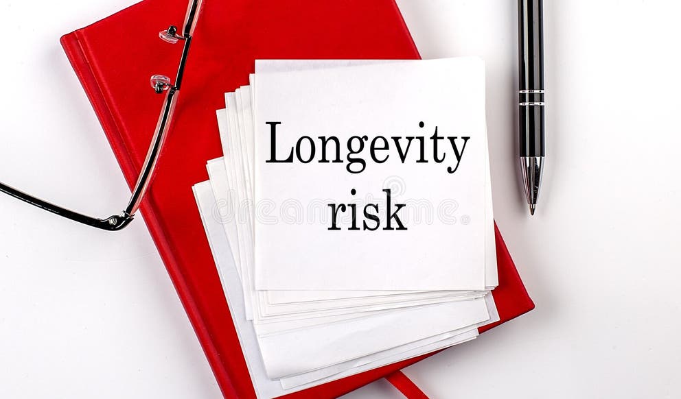 LONGEVITY RISK Text on Sticker on Red Notebook with Pen and Glasses ...