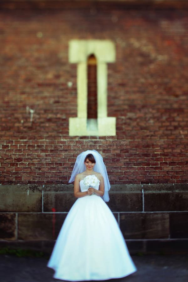 A Look from Afar on a Bride Standing Under a Small Window Stock Photo ...