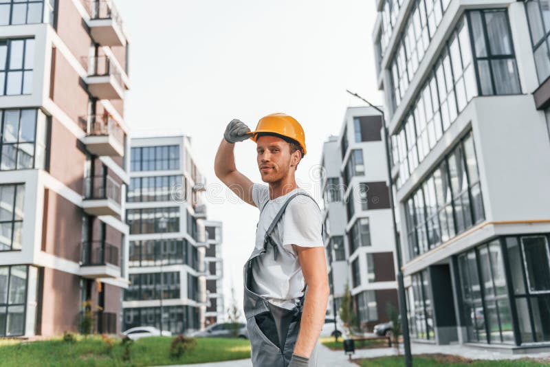 Looking at Buildings. Young Man Working in Uniform at Construction at ...