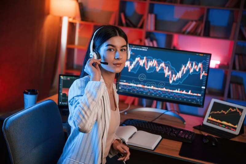 Looking into the Camera. Female Stock Trader is Working by Pc Indoors ...