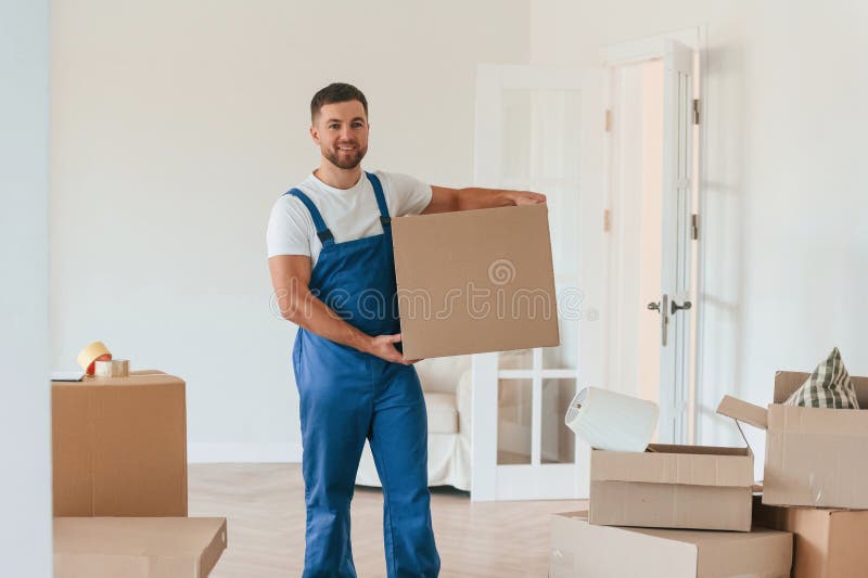 Looking at the Camera, Holding Box. Moving Service Employee in a Room ...