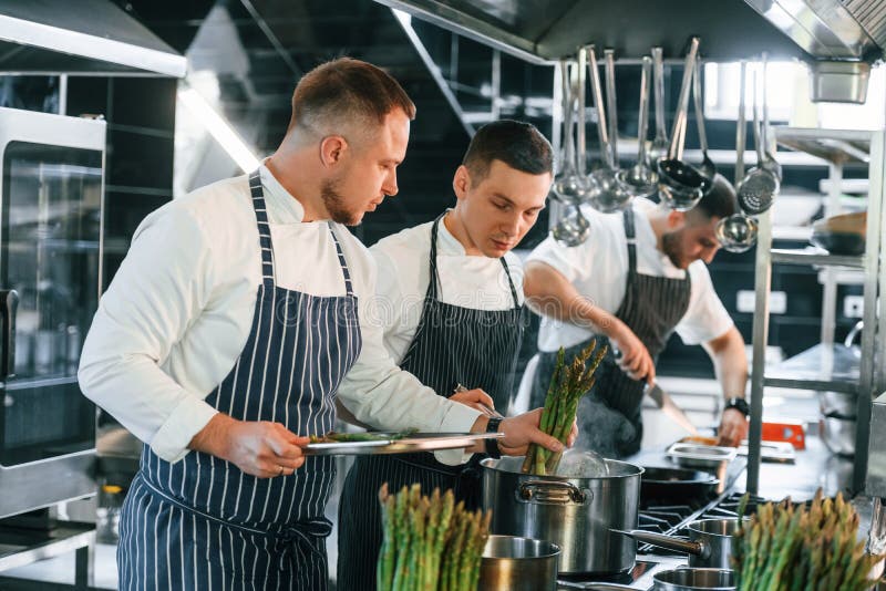 Looking at the Documents. Kitchen Workers is Together Preparing the ...