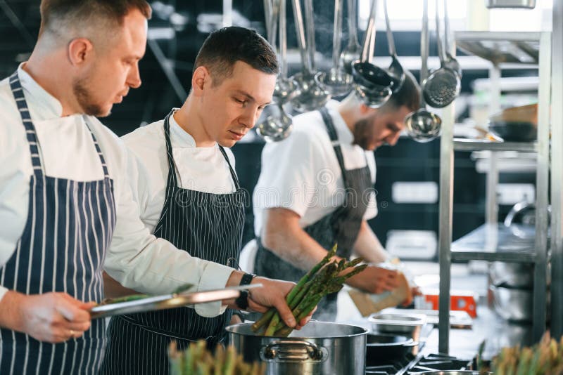 Looking at the Documents. Kitchen Workers is Together Preparing the ...
