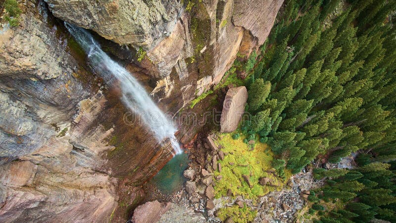 Looking Down at Large Waterfall from Cliffs into Mossy Rocks and Pine ...