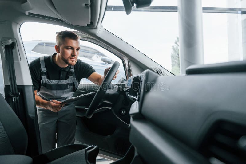 Looking Inside the Car. Man in Uniform is Working in the Autosalon at ...