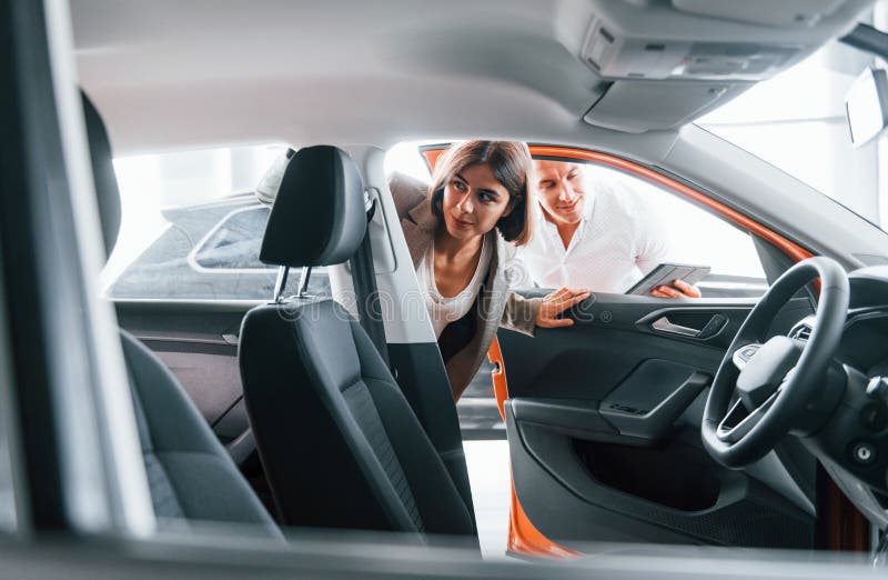 Looking at Interior. Man in Formal Wear Helping Customer with Choice of ...