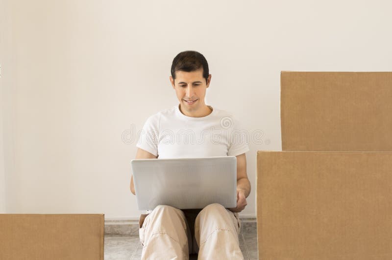 Man Moving into New Home Using Laptop Computer Stock Image - Image of ...