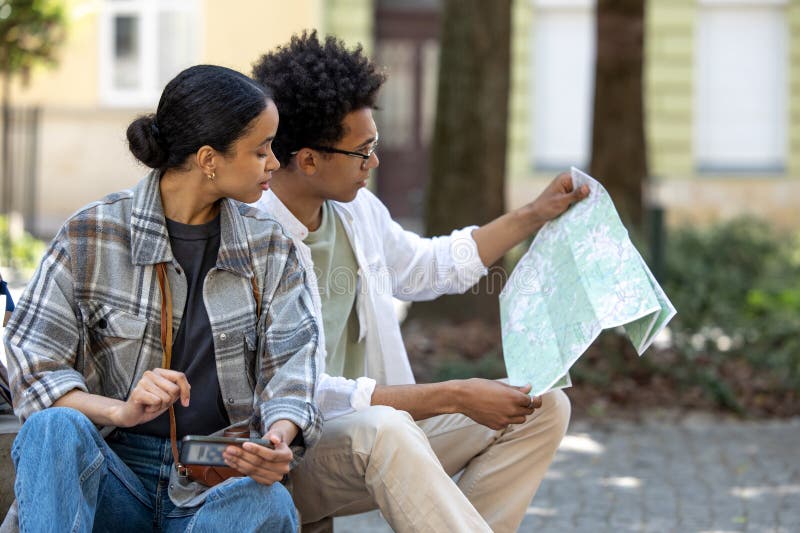 Young People Scrutinizing the Map and Discussing the Route Stock Image ...