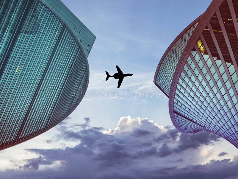 A Looking at the Sky with the Silhouette of Flying Plain Over the City ...
